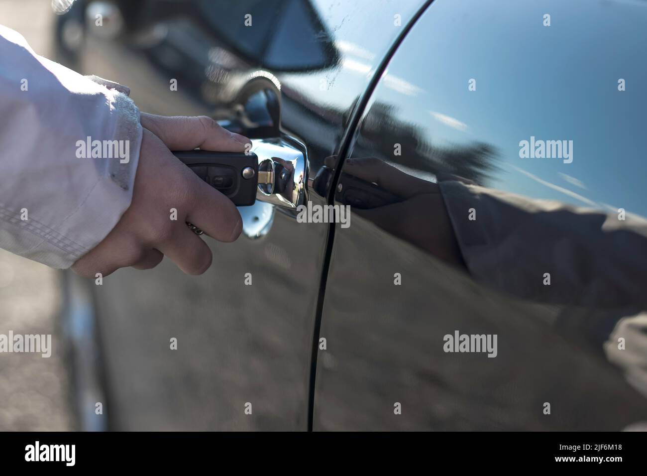 Cropped image of woman inserting key in car door Stock Photo - Alamy