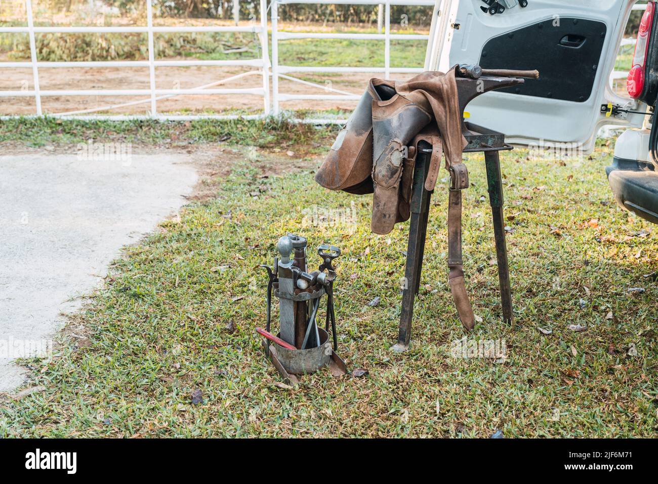 Farrier tools placed near anvil with chaps outside van with opened ...