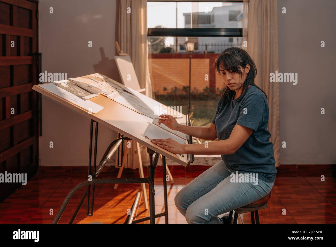 Side view of Woman at home relaxed drawing and painting close to the ...