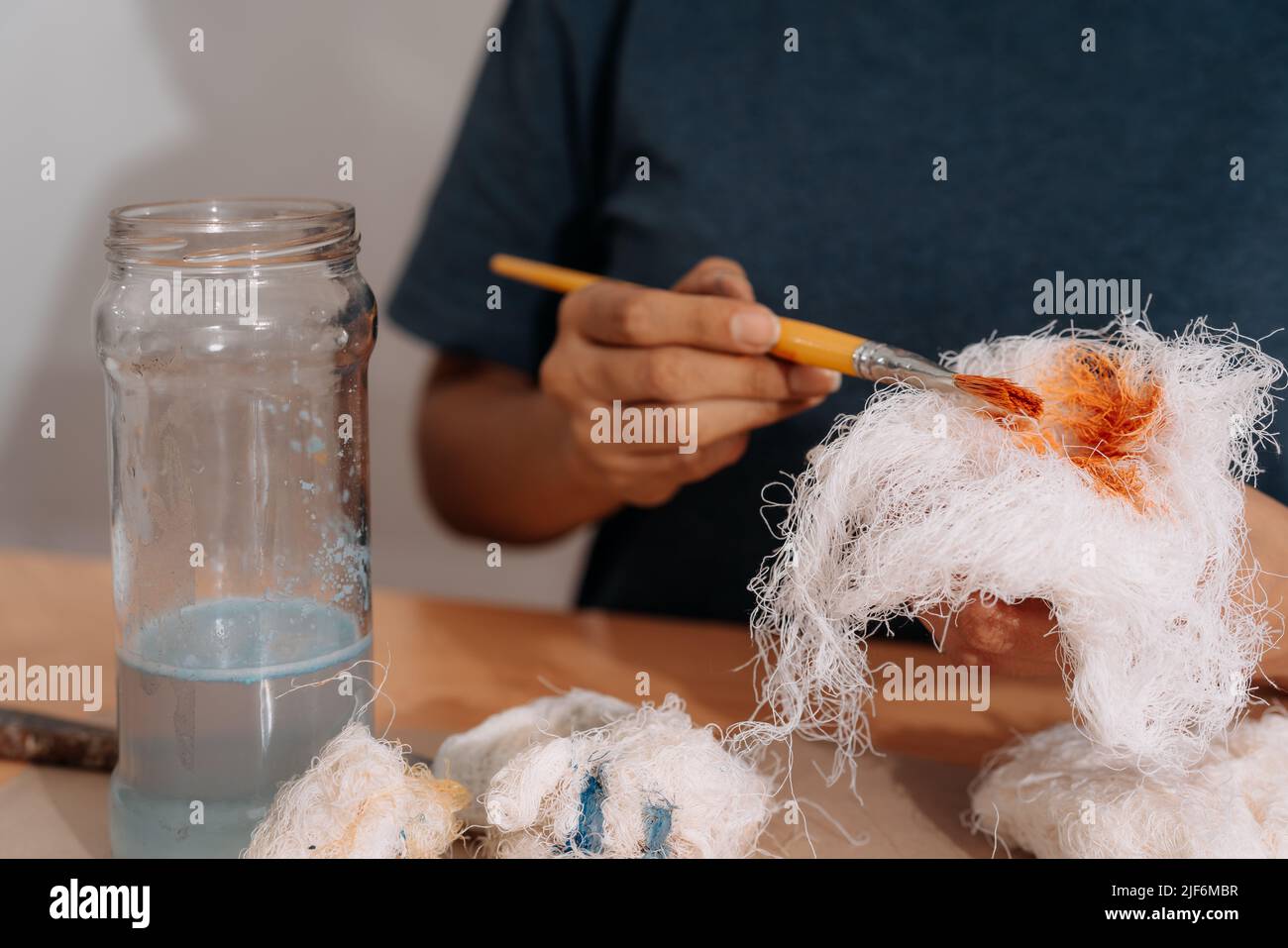 anonymous Woman washing painting brush with water and cleaning material ...