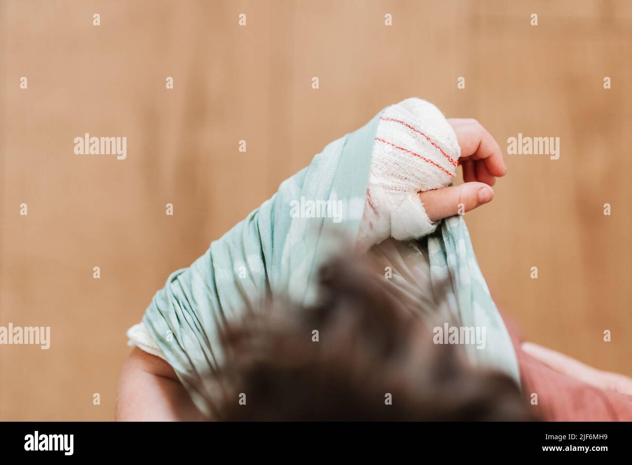 Soft focus top view of anonymous kid putting injured arm with plaster ...