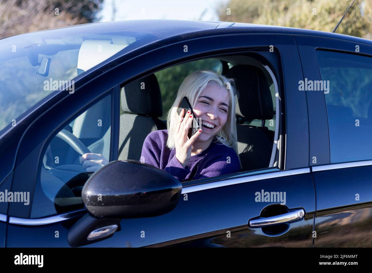 Young woman driver talking by phone in the car Stock Photo - Alamy