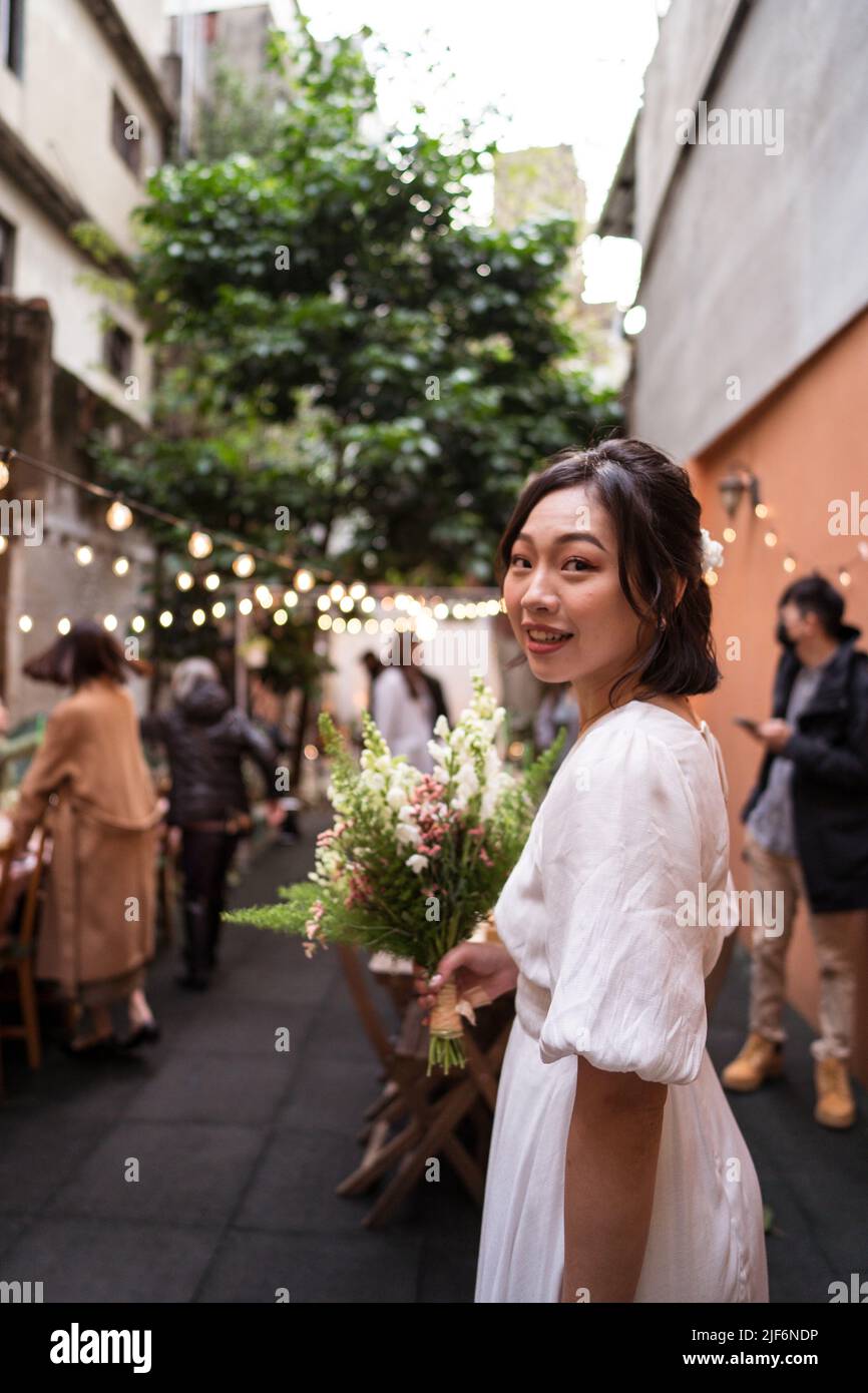 Happy Asian Woman in white wedding dress smiling and looking at camera ...