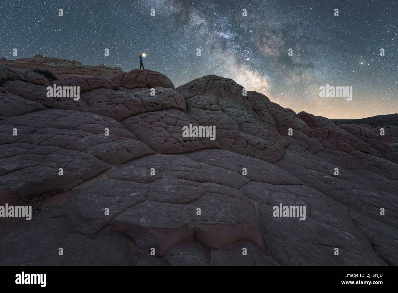 Silhouette of unrecognizable explorer standing with flashlight on ...