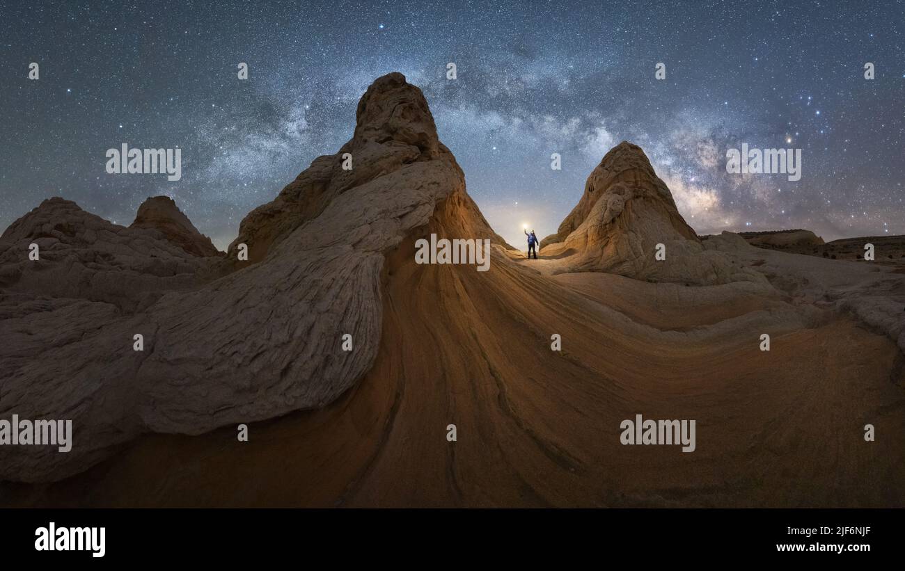 Silhouette of unrecognizable explorer standing with flashlight on ...