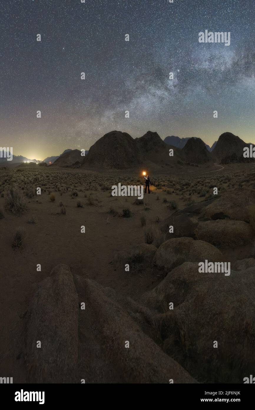 Silhouette of unrecognizable explorer standing with flashlight on ...