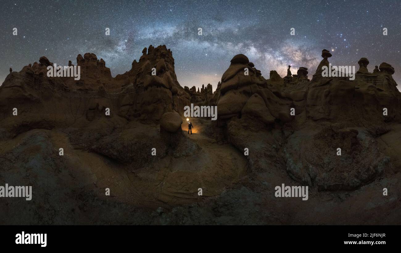 Silhouette of unrecognizable explorer standing with flashlight on ...