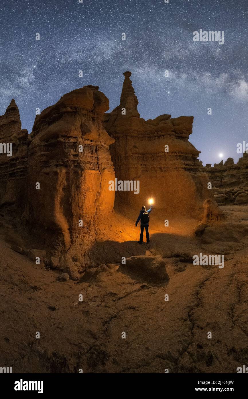 Silhouette of unrecognizable explorer standing with flashlight on ...