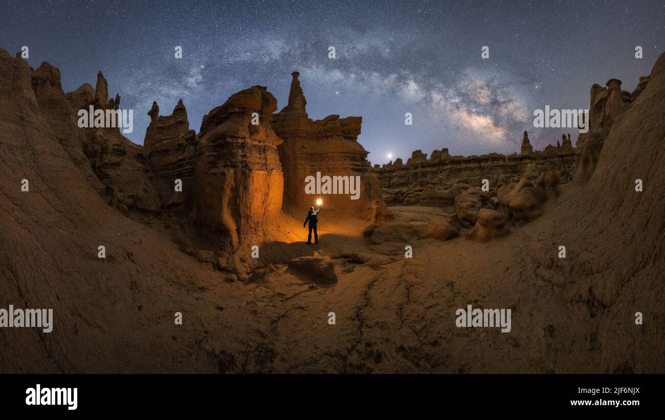 Silhouette of unrecognizable explorer standing with flashlight on ...