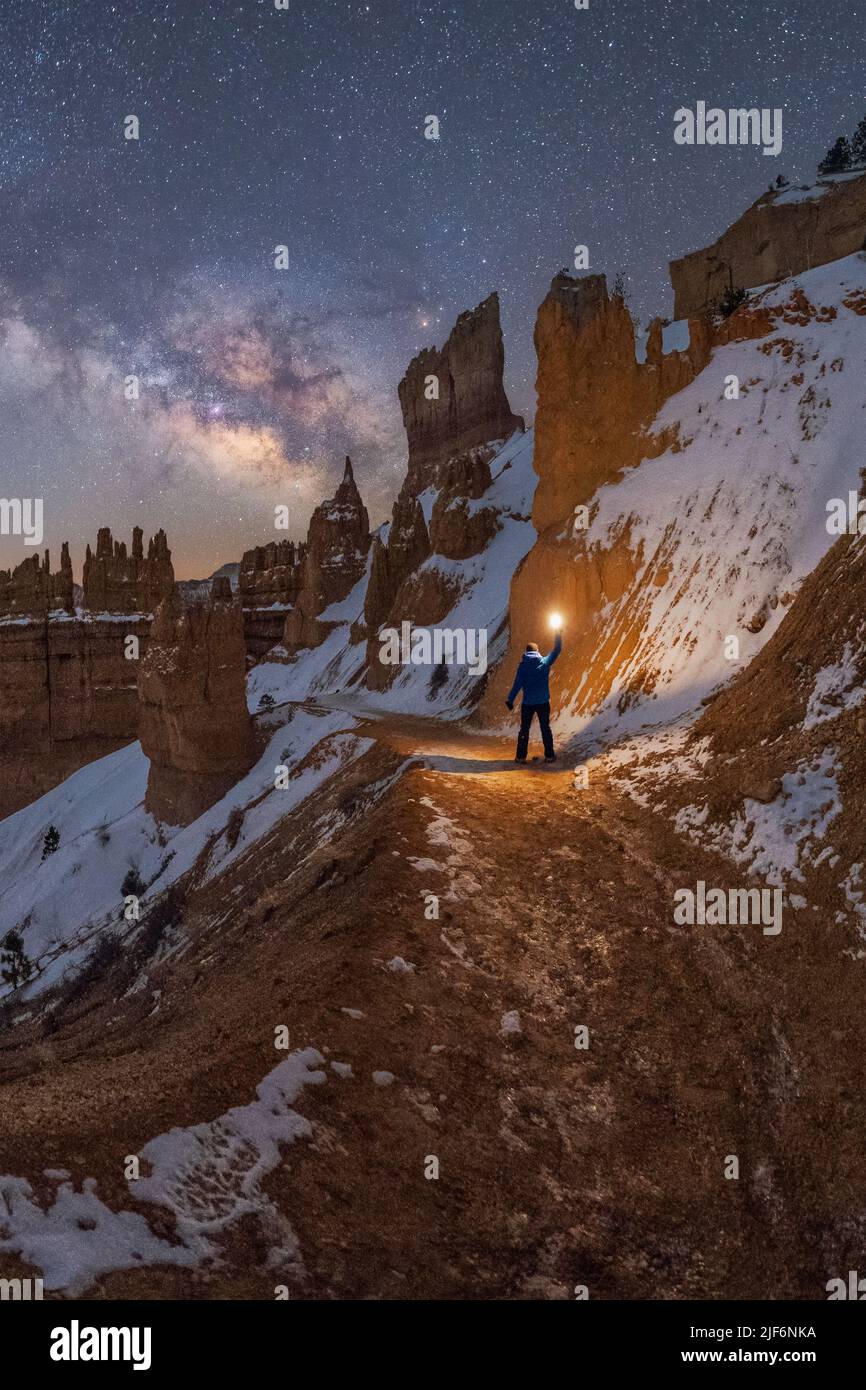 Silhouette of unrecognizable explorer standing with flashlight on ...