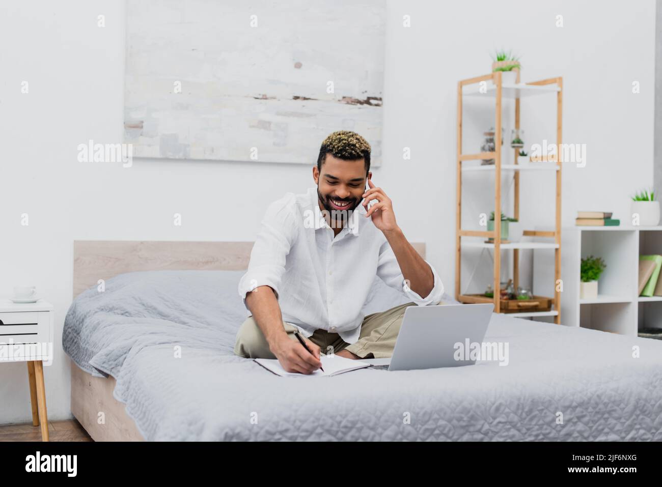 happy african american man smiling while talking on smartphone and ...