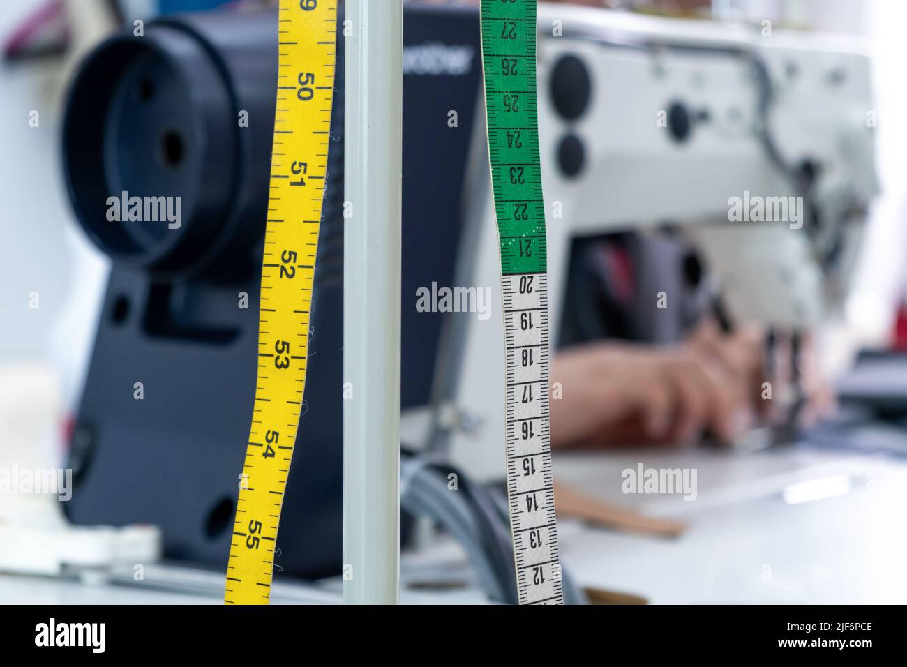 Soft focus of colorful long measuring tape hanging near faceless master ...