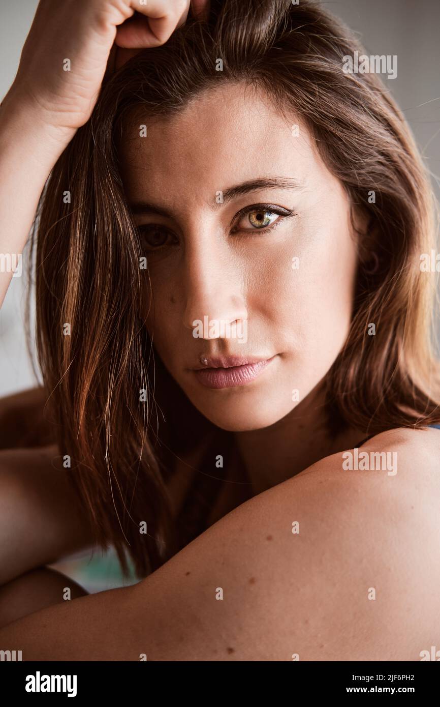 Attractive female model with brown hair looking into distance with sincere face expression with ...