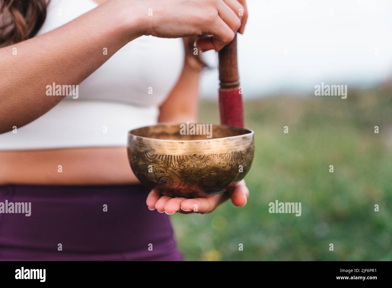 Unrecognizable female athlete in sportswear playing standing bell and ...