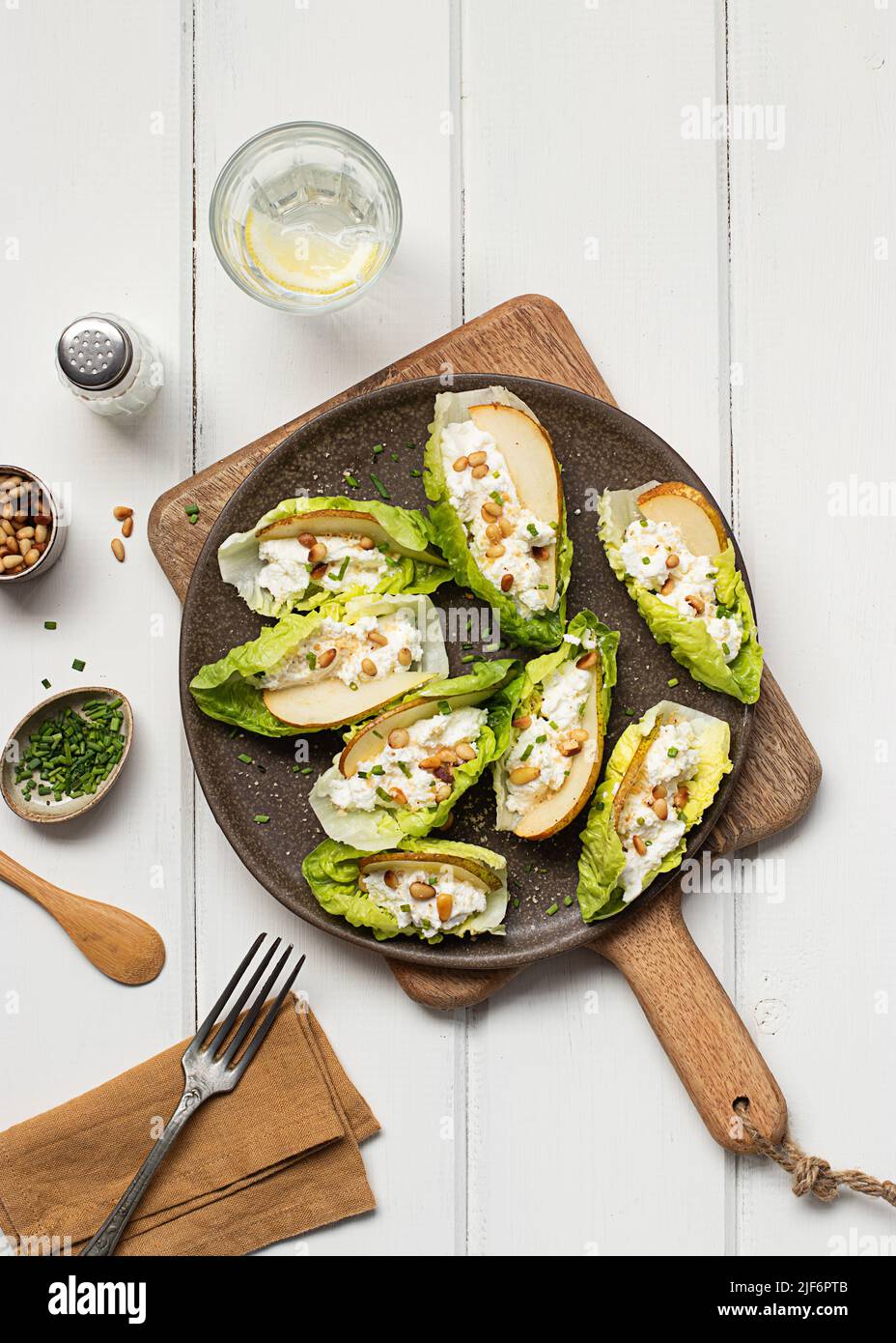 From above pear ricotta salad with lettuce on wooden cutting board on ...
