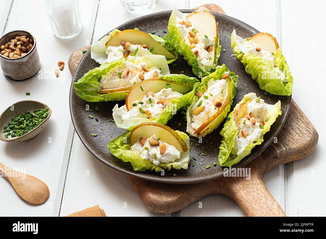 From above pear ricotta salad with lettuce on wooden cutting board on ...