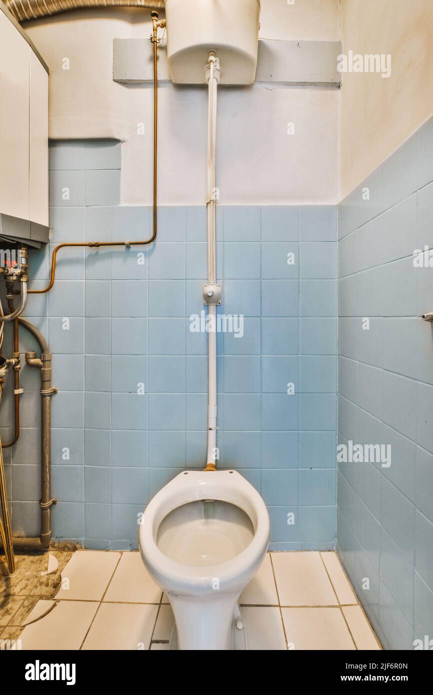 Old weathered toilet in bathroom with blue tiled walls Stock Photo - Alamy