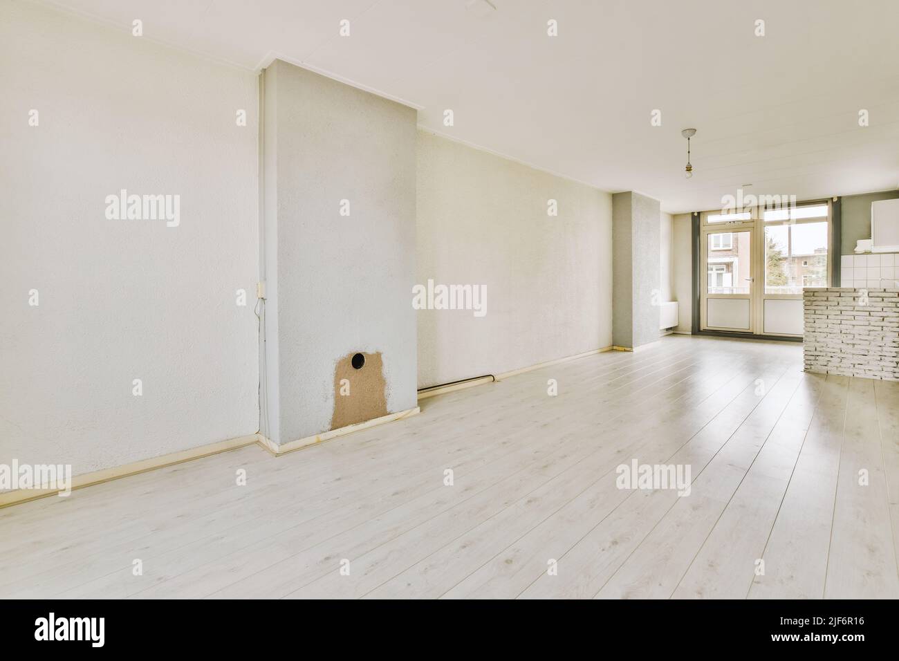 Interior of empty open plan white kitchen with windows and wooden ...