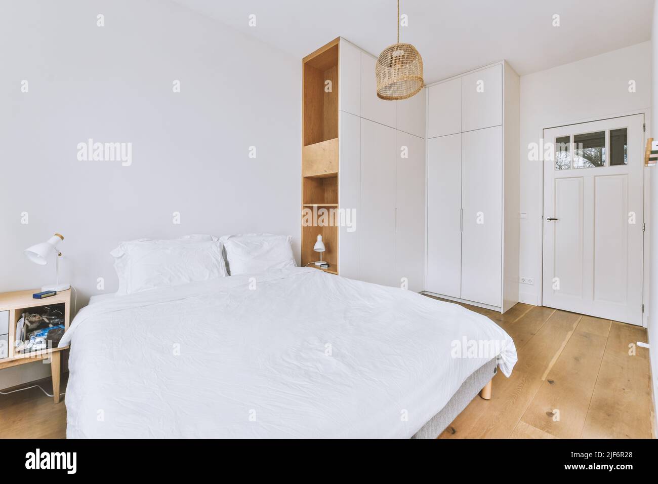 Home interior design of bedroom with bed and wooden wardrobe placed in ...