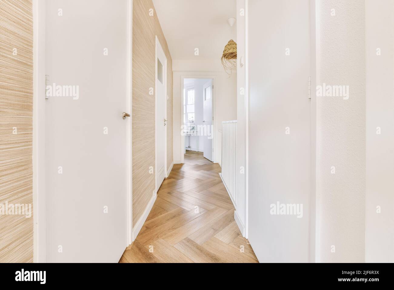 Light narrow hallway with many doors in white walls and glowing lamp ...