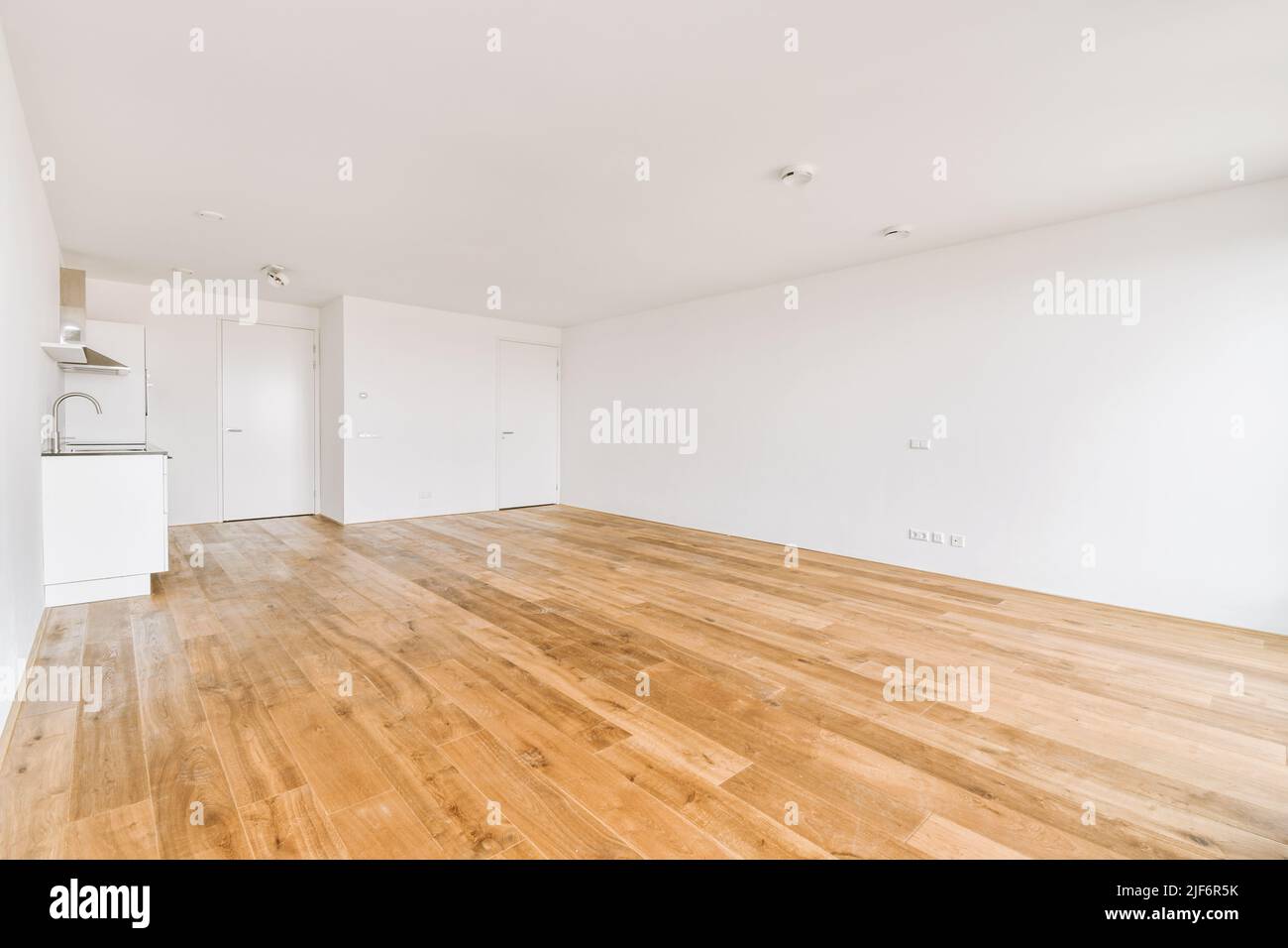 Interior of empty white kitchen with windows and wooden parquet floor ...