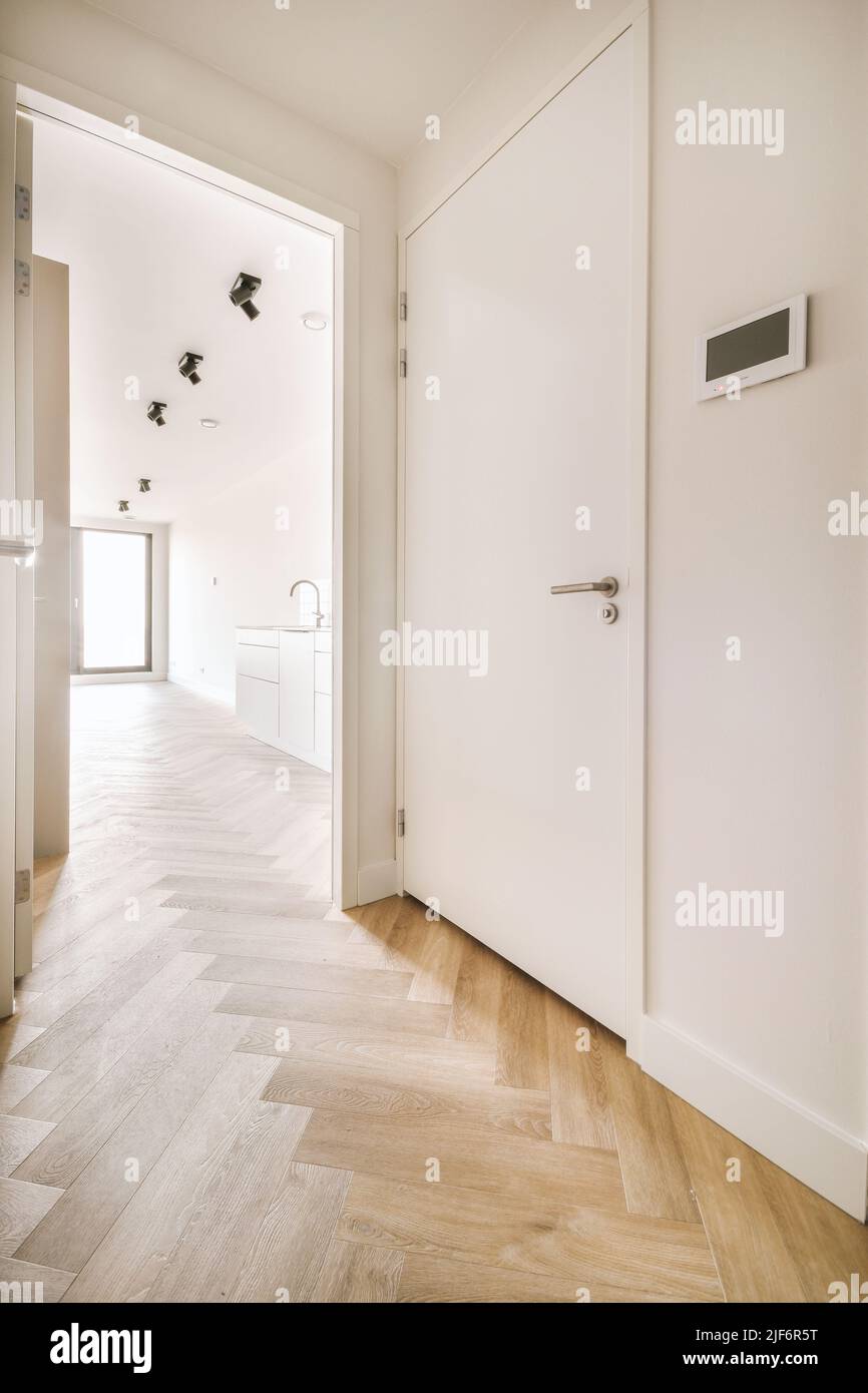 Light narrow hallway with many doors in white walls and glowing lamp ...