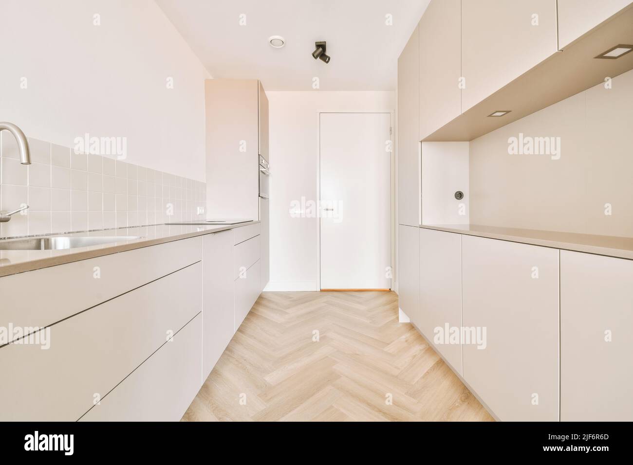 Interior of empty white kitchen with windows and wooden parquet floor ...