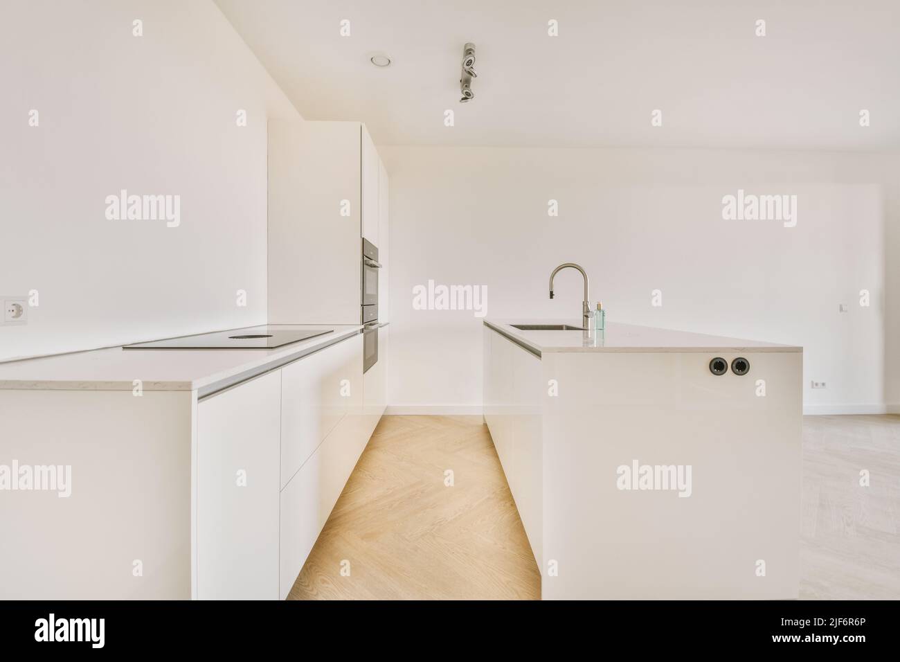 Interior of empty open plan white kitchen and wooden parquet floor ...