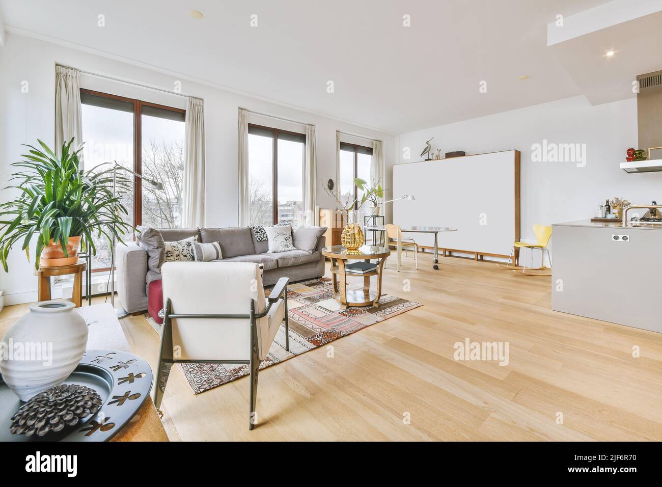 Interior of spacious open space room with lounge and dining zones in ...