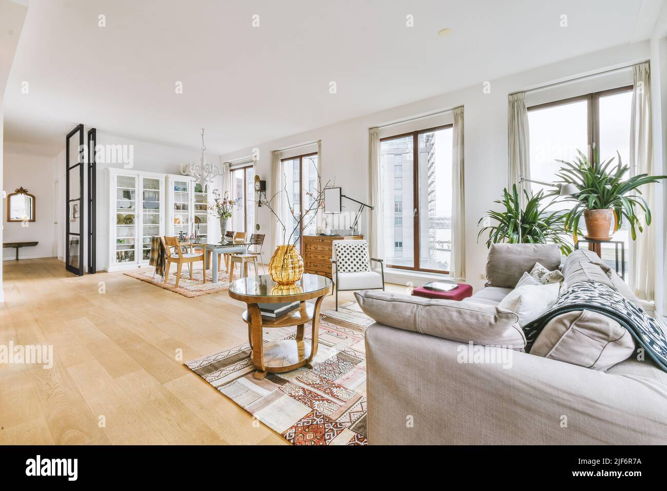 Interior of spacious open space room with lounge and dining zones in ...