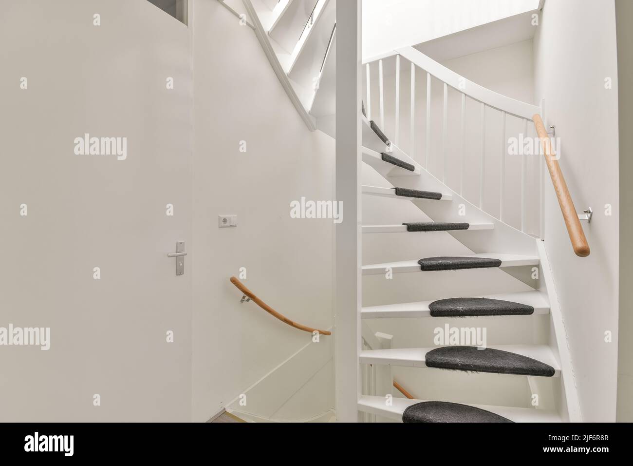 White spiral staircase leading to upper floor in light corridor Stock ...