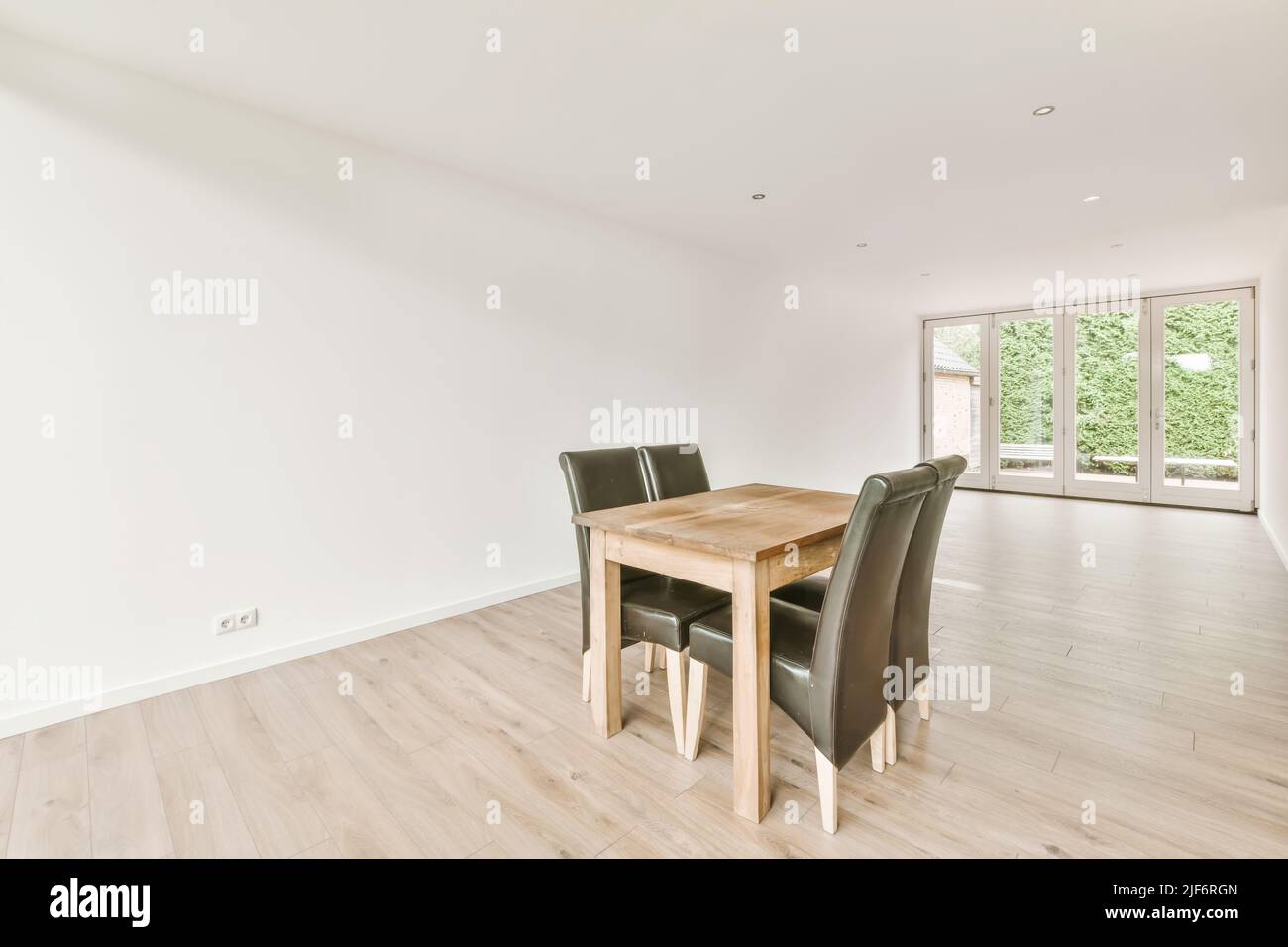 Chairs at dining table placed near glass doors in spacious room with ...