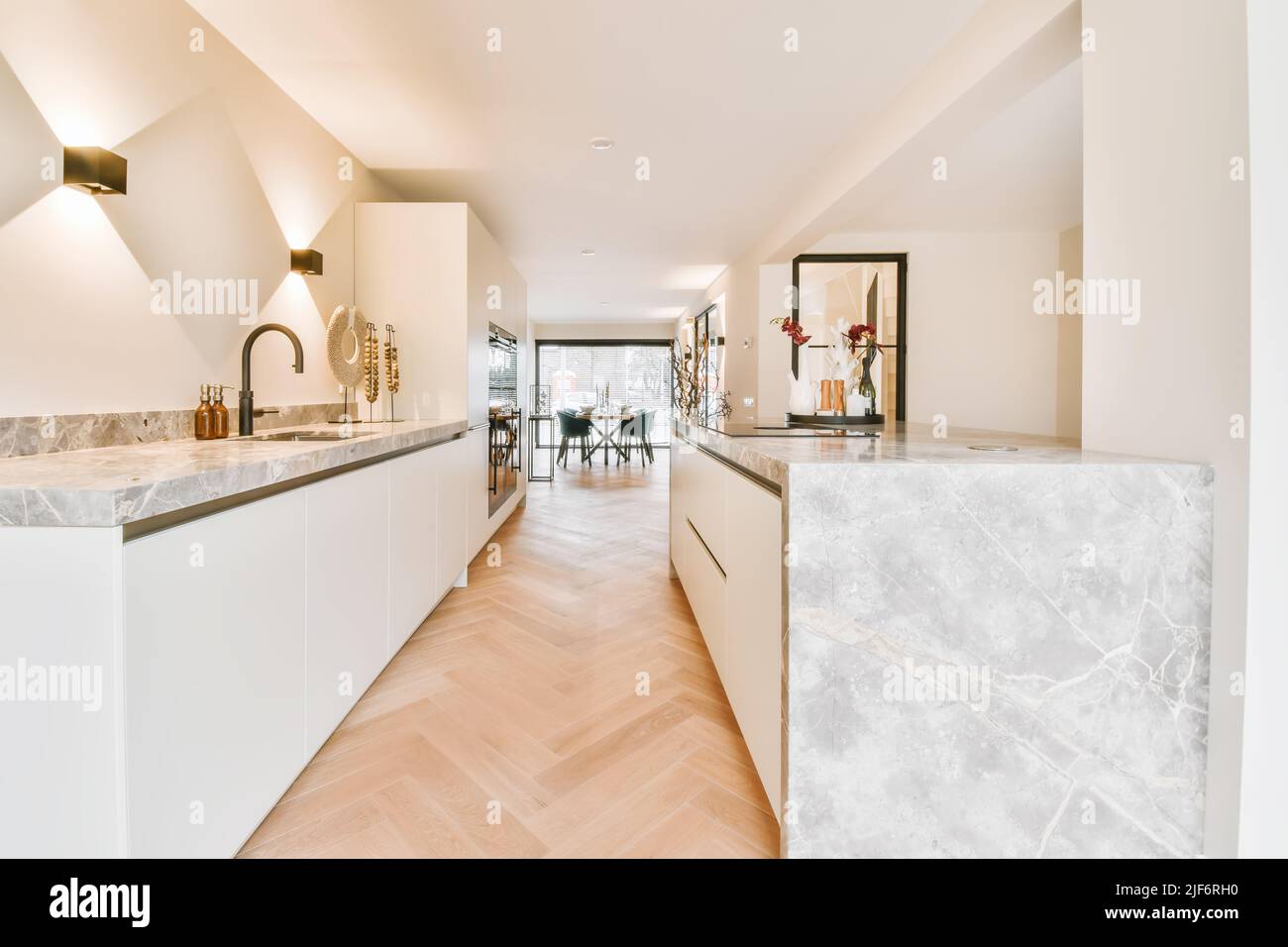 Marble counters with sink at wall with glowing lamps in stylish kitchen ...