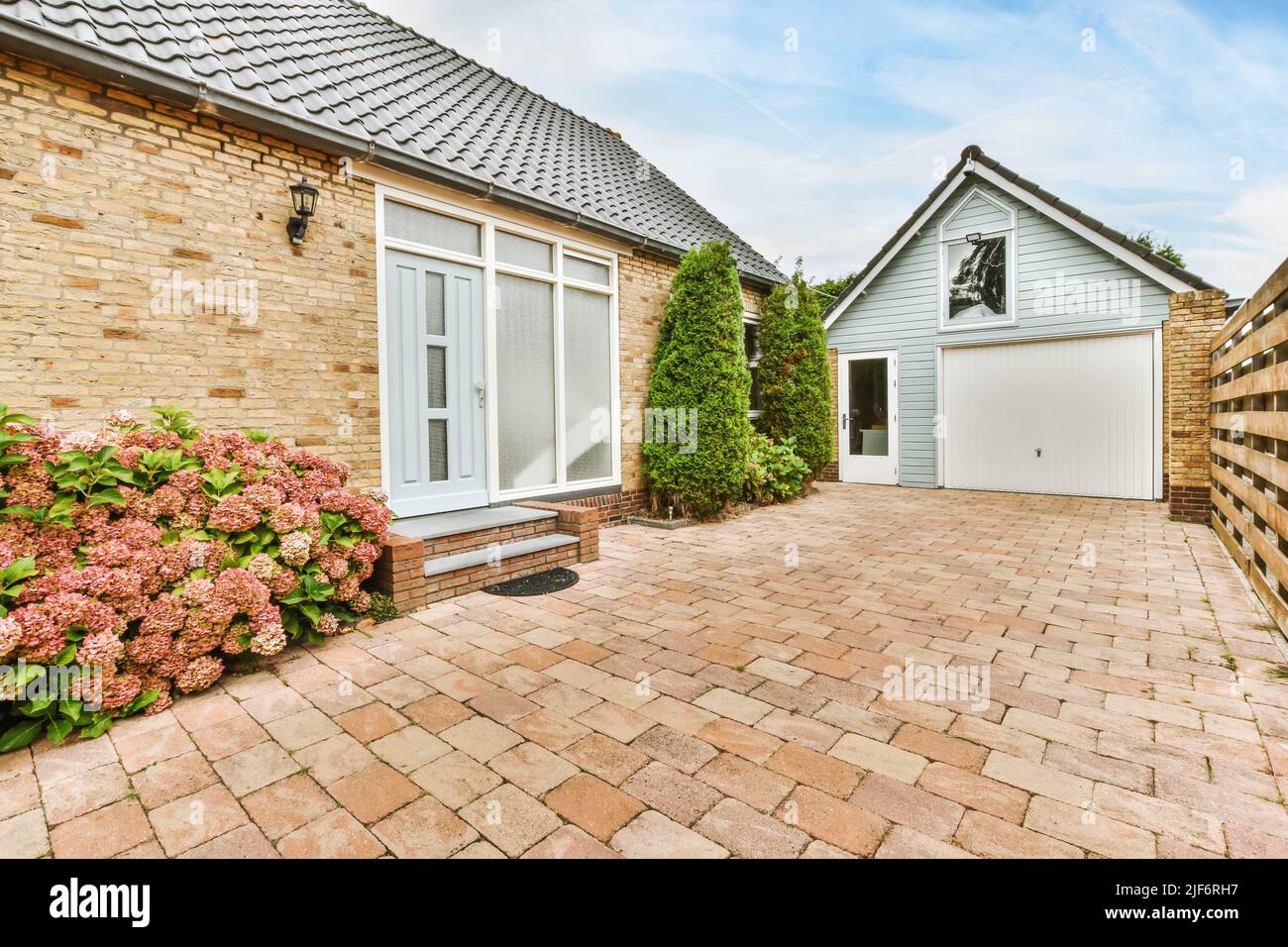 Residential house with glass door near patio with paved walkway and ...