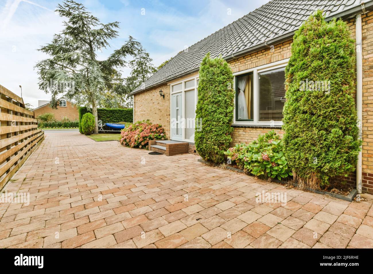 Residential house with glass door near patio with paved walkway and ...