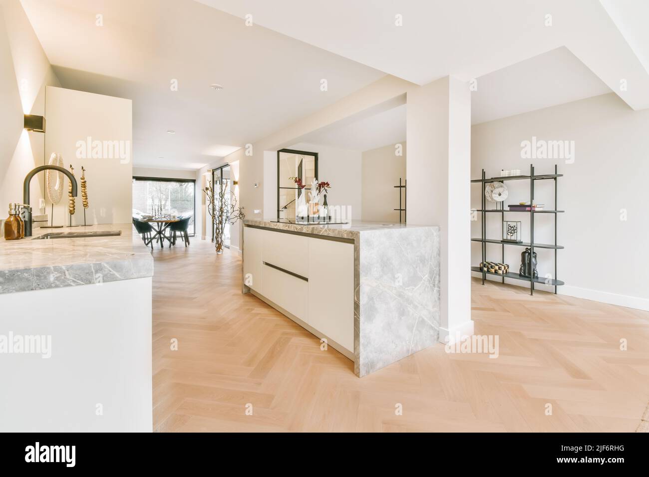 Marble counters with sink at wall with glowing lamps in stylish kitchen ...