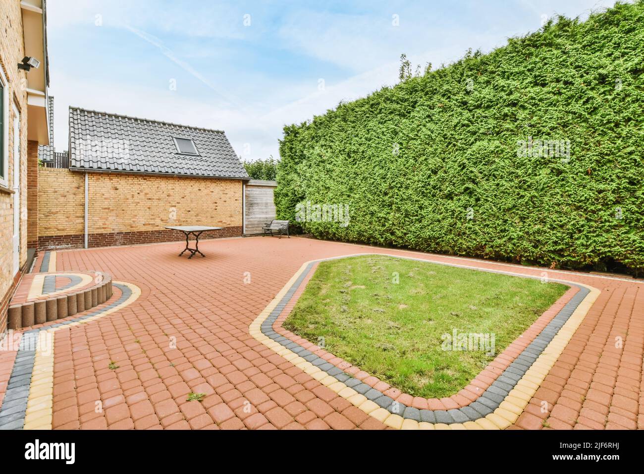 Patio of residential building with table placed on colorful paved ...