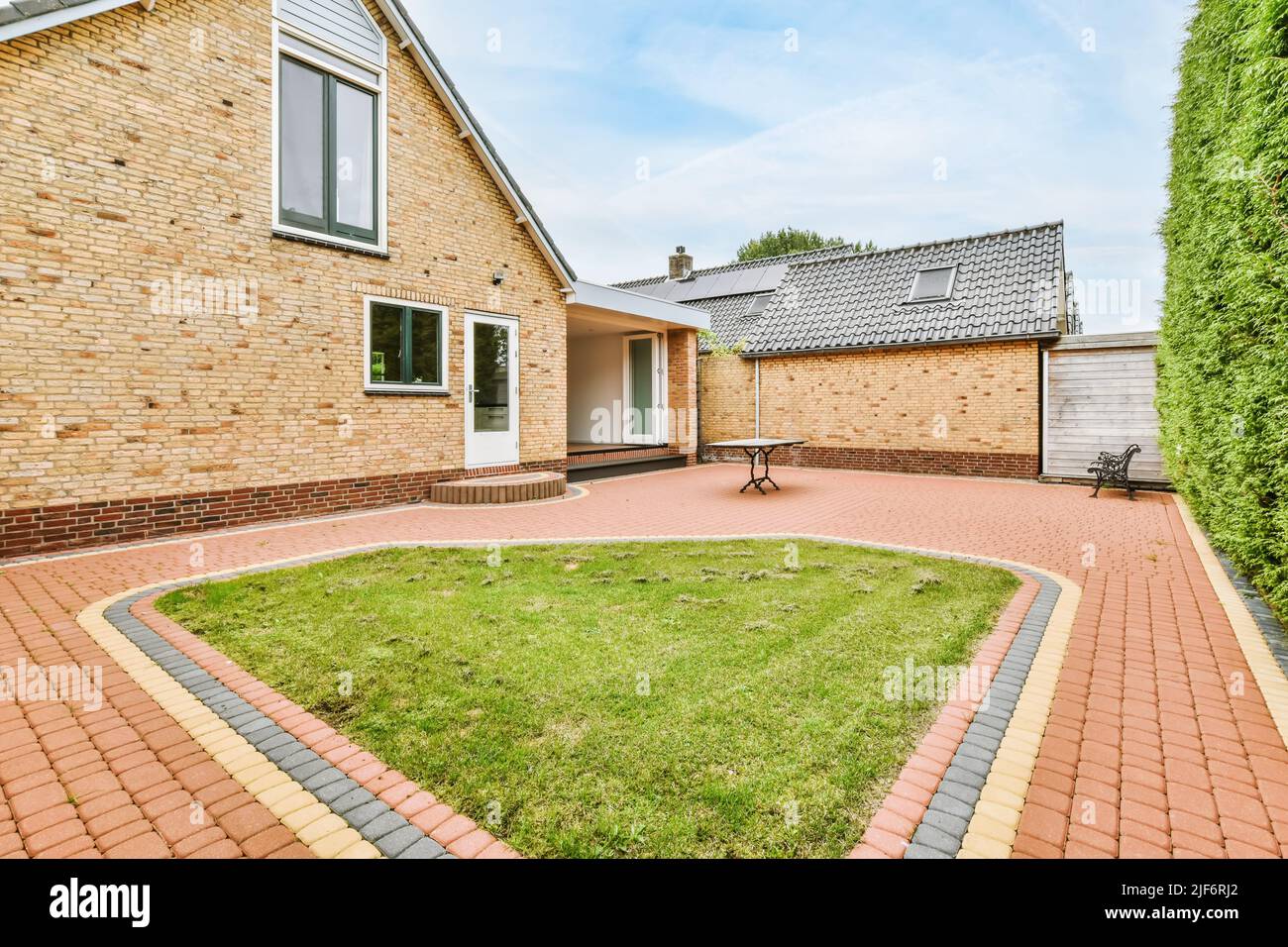 Patio of residential building with table placed on colorful paved ...
