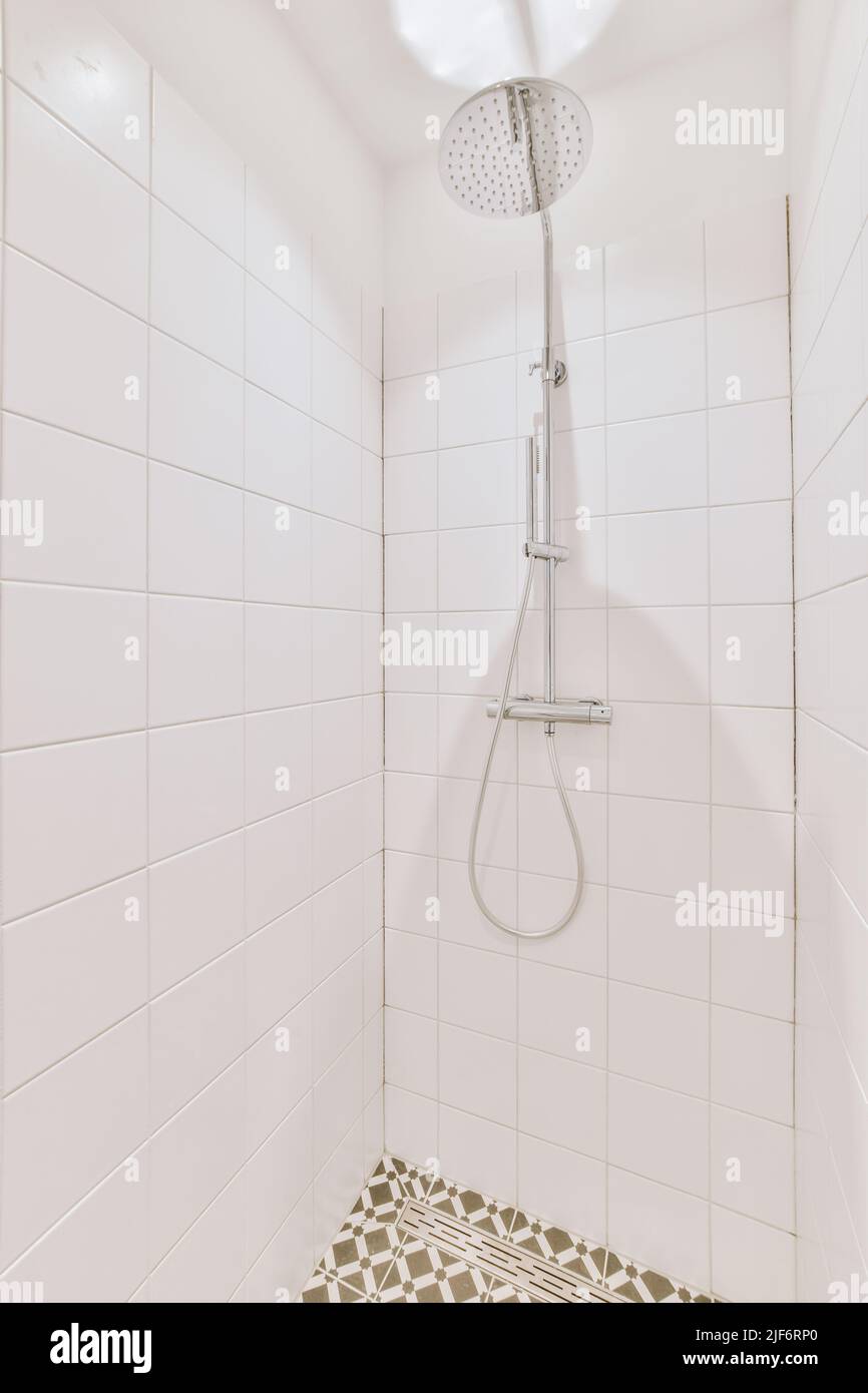 Interior of modern shower cabin with tiled walls and built in shelf and ...