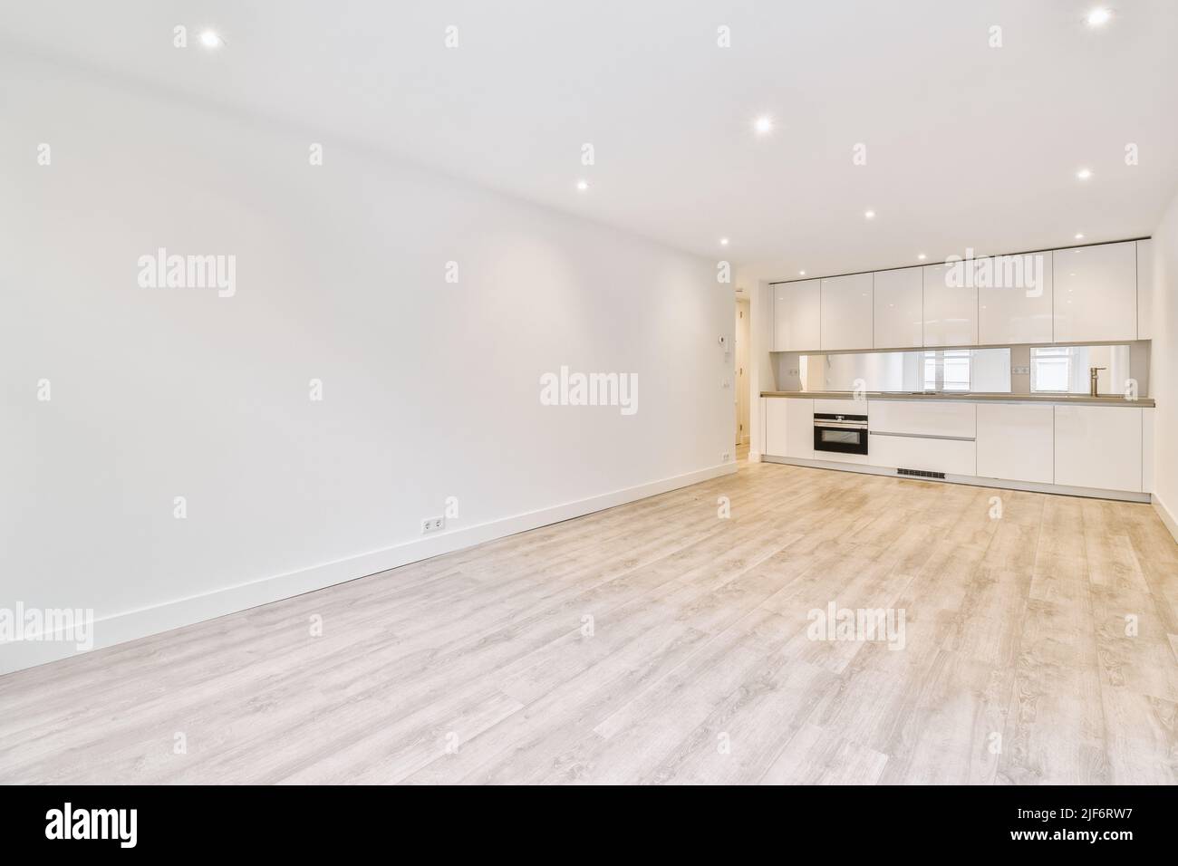 Interior of empty white kitchen with windows and wooden parquet floor ...