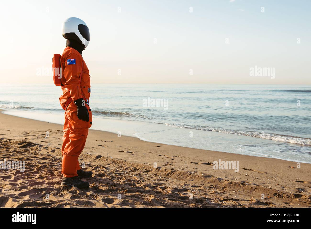 Side view of astronaut in futuristic spacesuit and helmet standing on ...