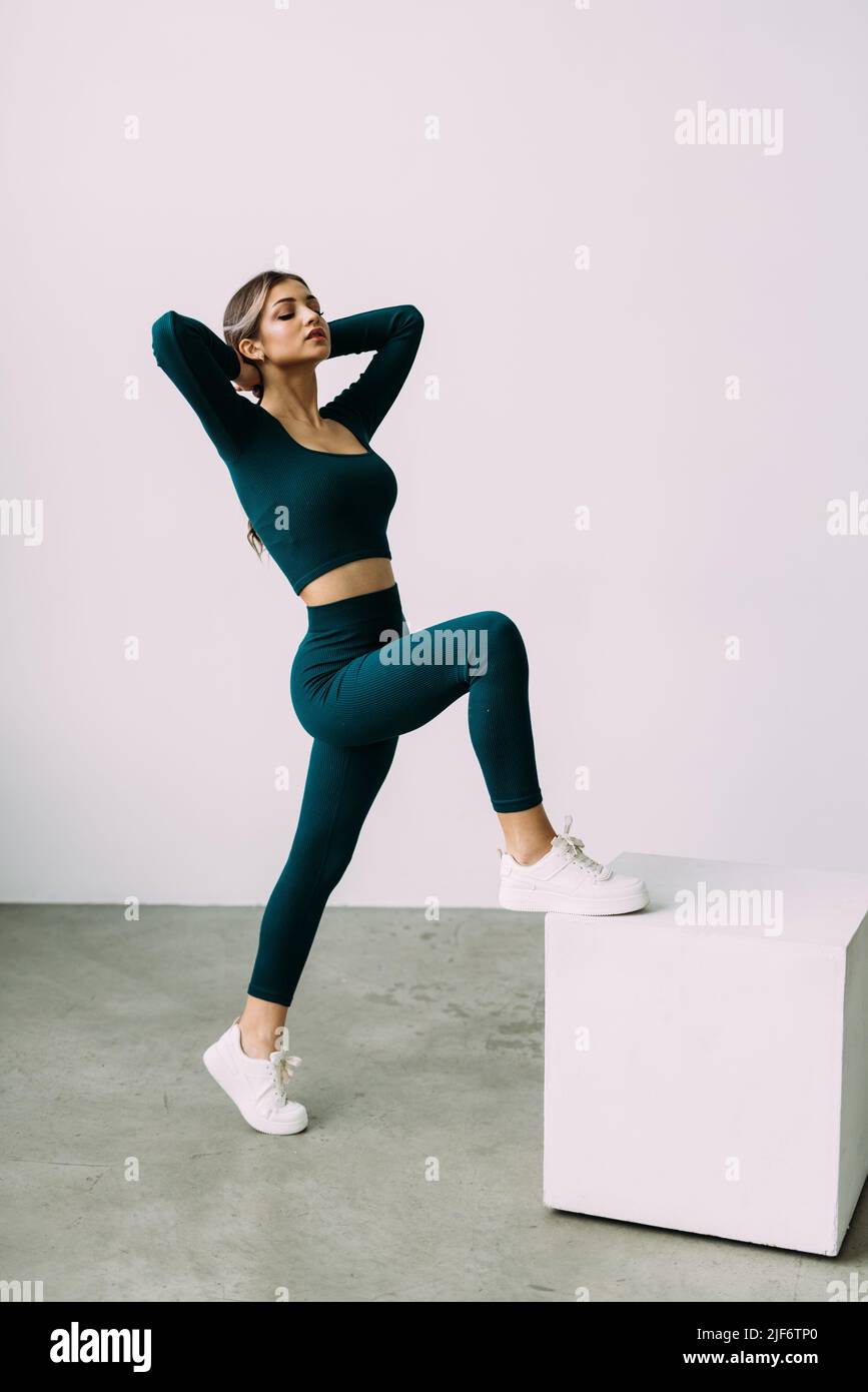 well-built sweaty girl doing box jump at sport center. full length side ...