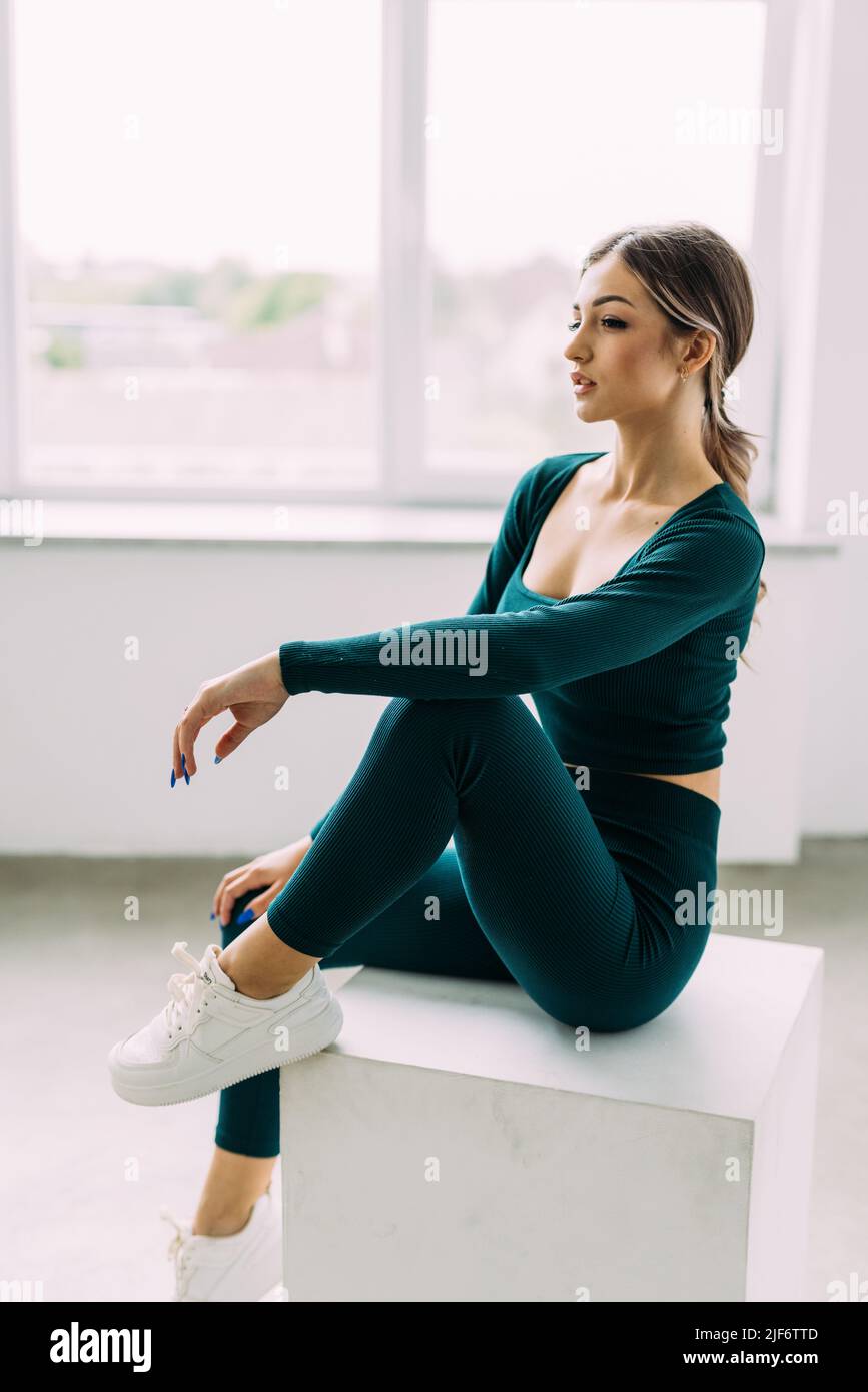 Slim sport woman in sportswear jumping on fit box and do squats ...