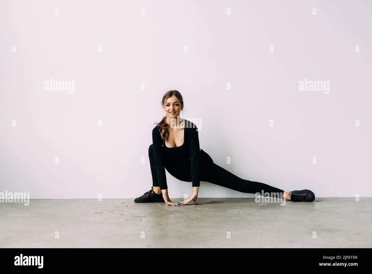 Fitness woman doing stretching workout. Full length shot of young woman ...