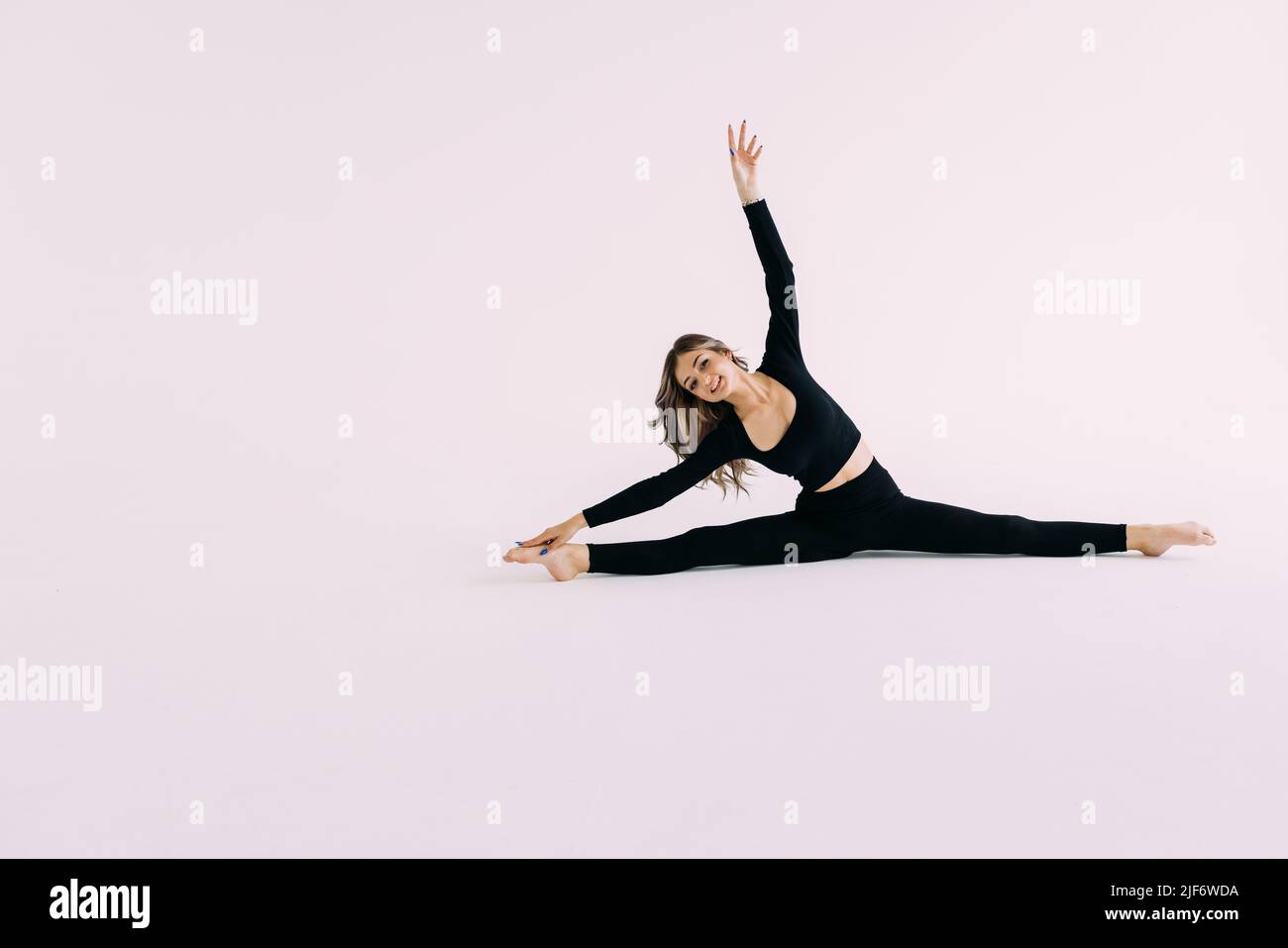 Fitness woman leg split on white background Stock Photo - Alamy