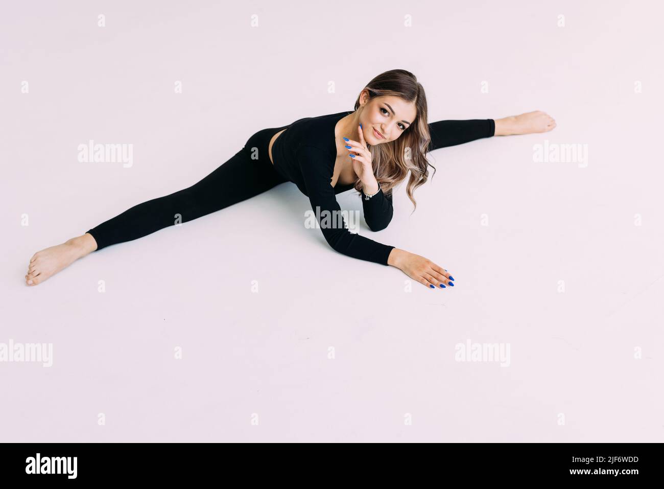 Fitness woman leg split on white background Stock Photo - Alamy