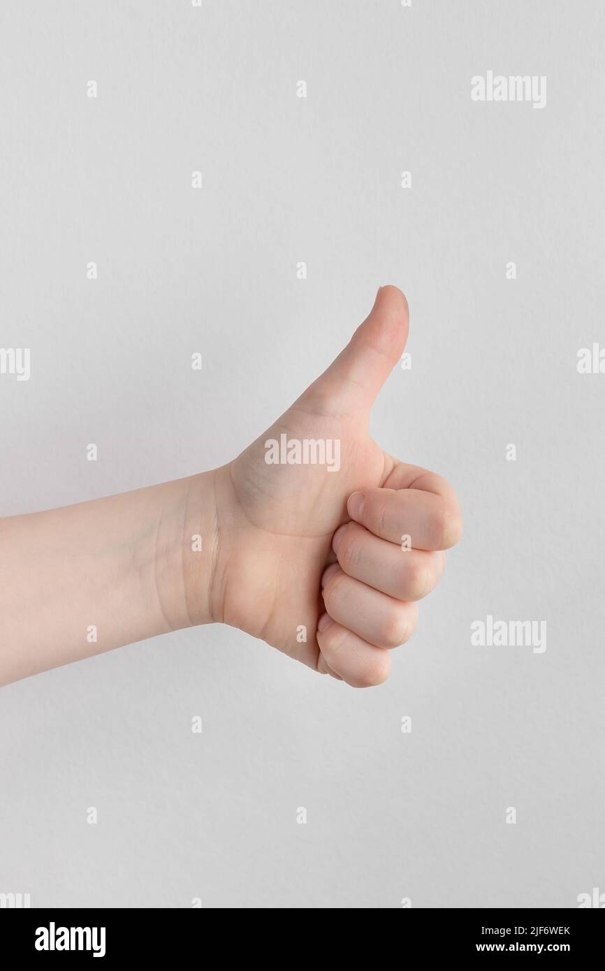 hand of kids or child hand showing thumbs up Isolated on white and gray ...