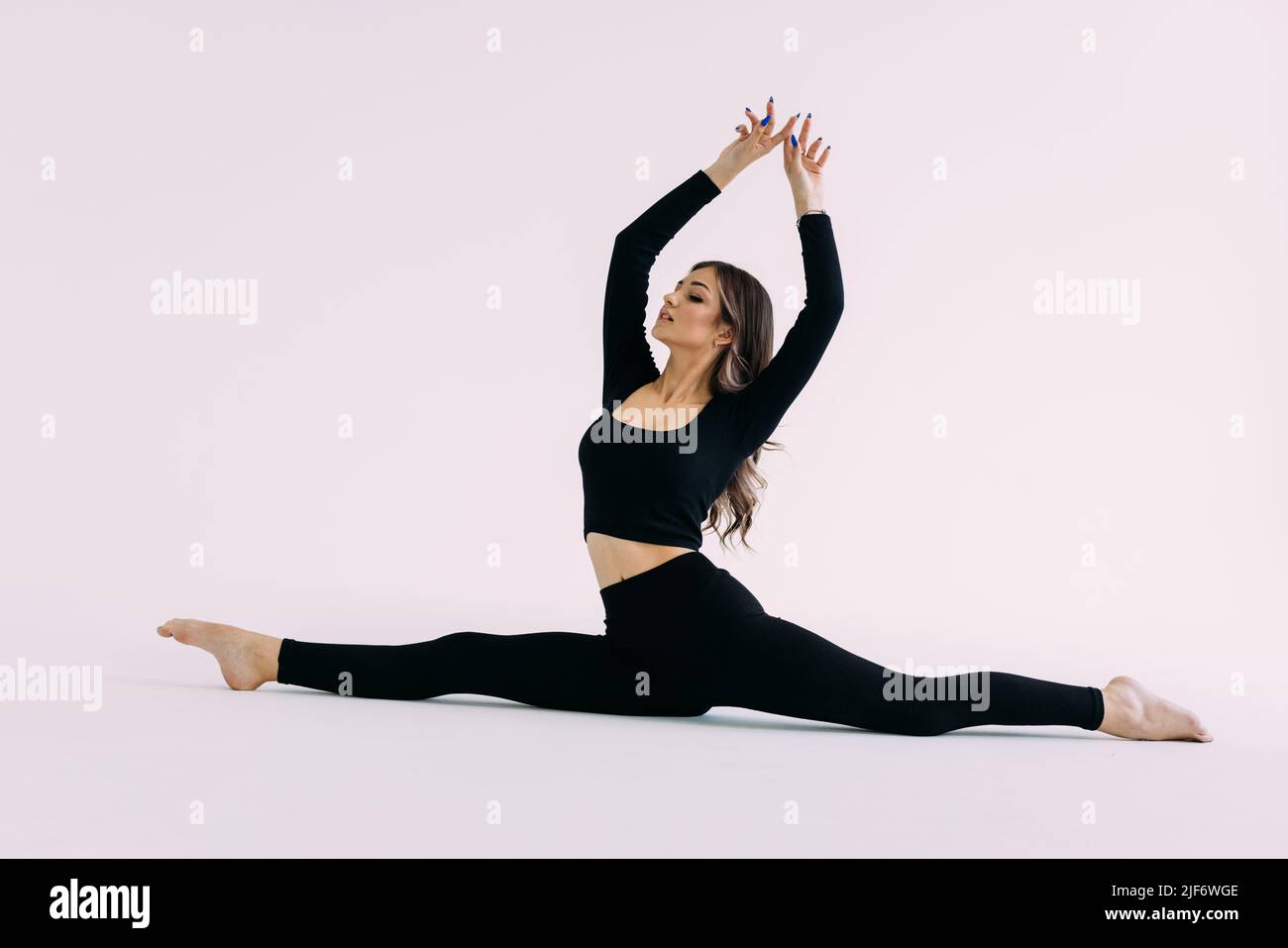 Fitness woman leg split on white background Stock Photo - Alamy