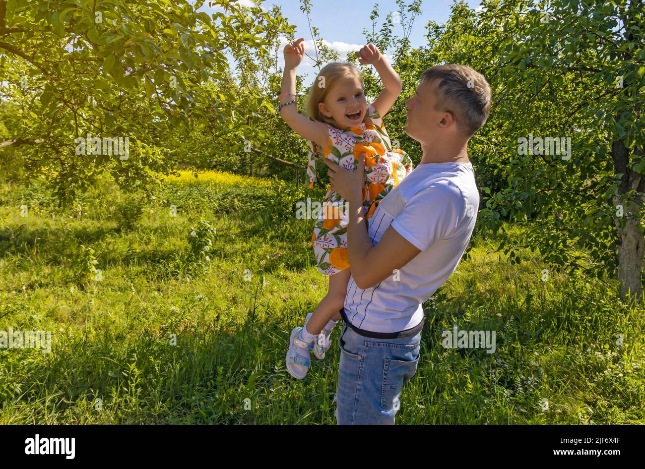 Happy little girl in her father's arms. Daughter plays and laughs in ...