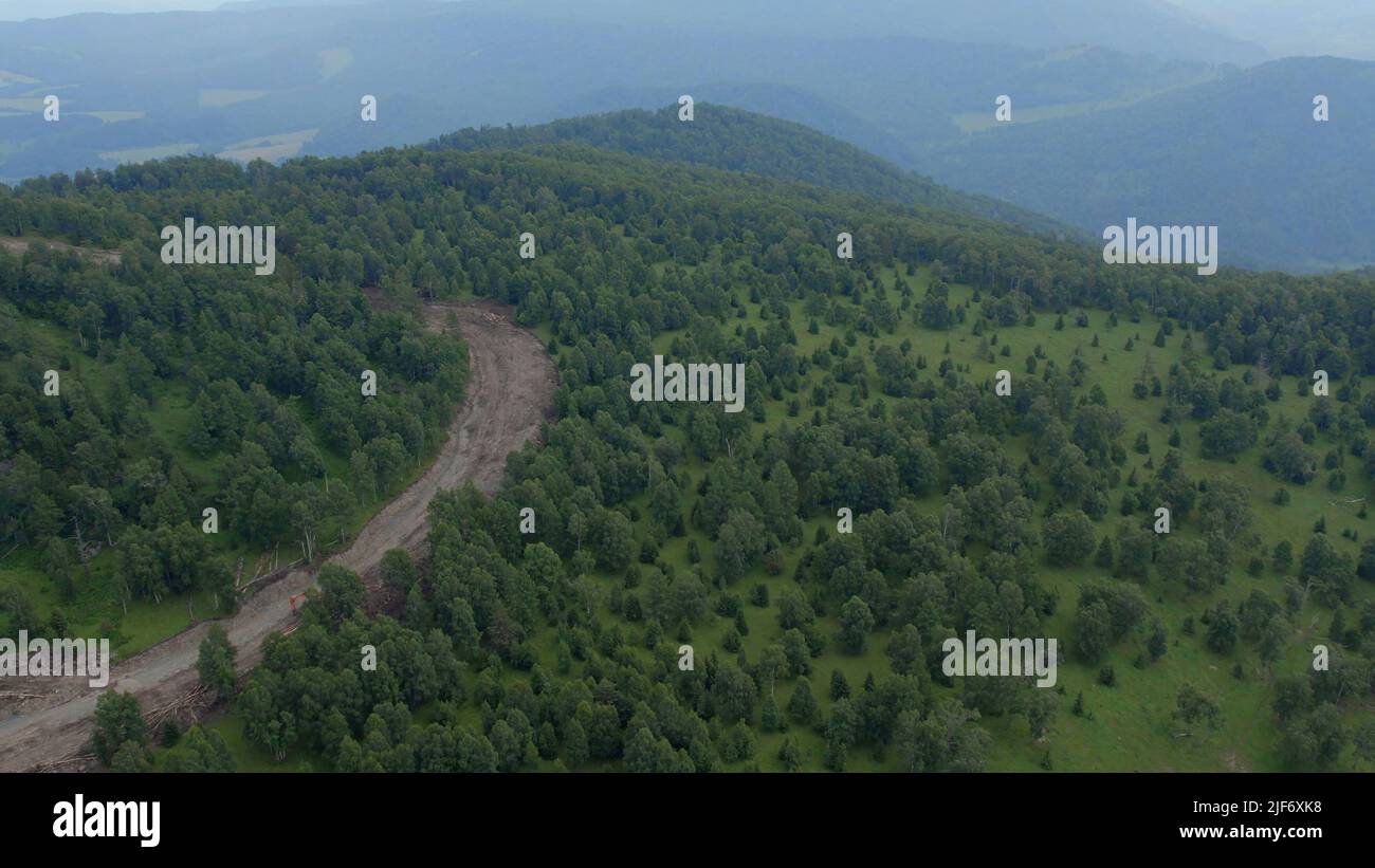 Green forest and rural road on mountains of Manzherok under white ...